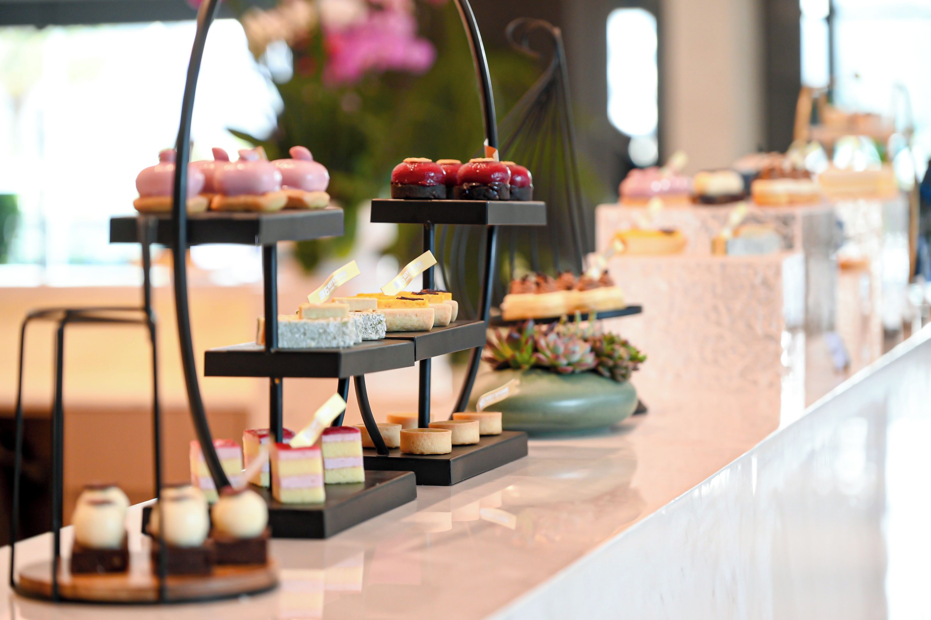 Buffet com diversos doces dispostos em suportes escalonados.