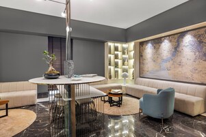 Uma sala de estar moderna com uma mesa redonda, um sofá e um grande quadro abstrato na parede.