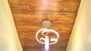 Corredor com teto de madeira e luminária moderna.