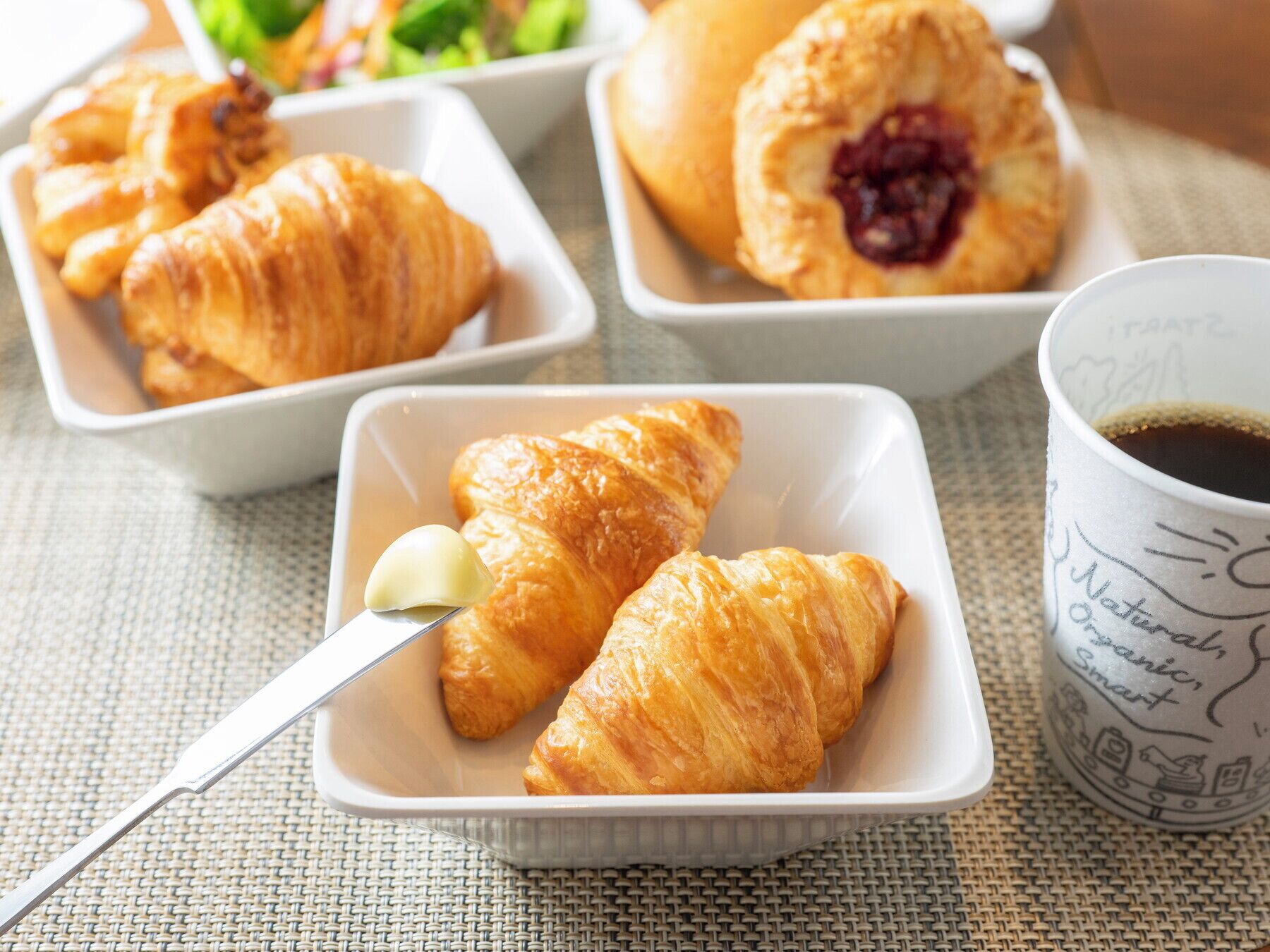 Uma mesa com croissants e uma xícara de café.