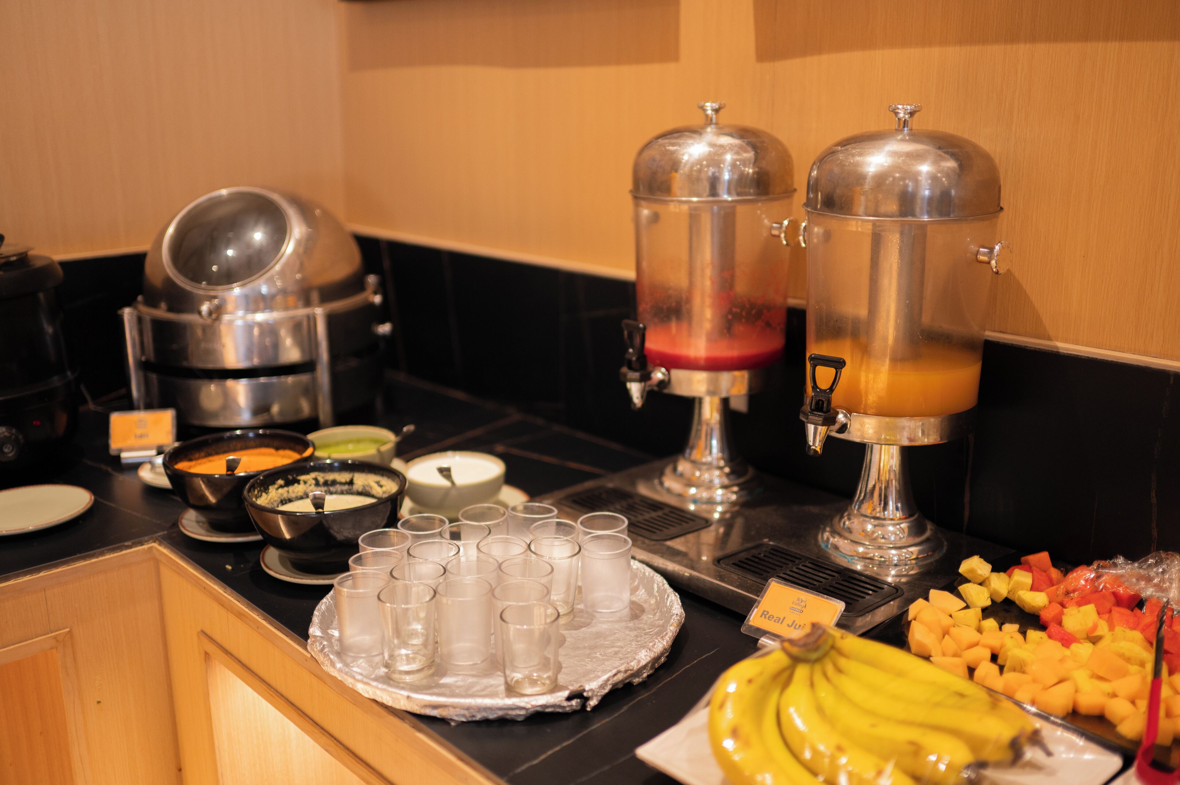 Disposição de buffet com diversos alimentos e dispensadores de bebidas.