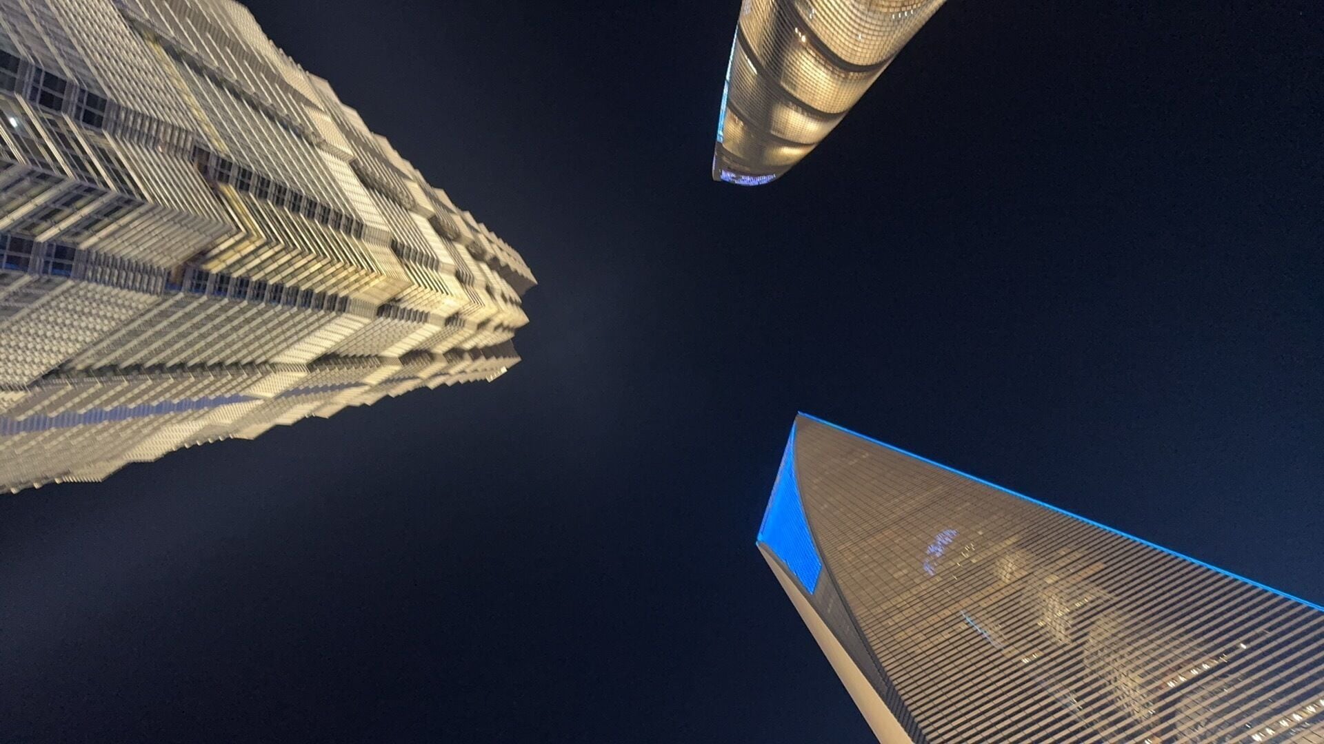 Um close-up da fachada de um edifício moderno com um design angular característico e janelas de vidro refletivas.