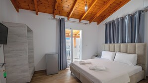Quarto com cama, guarda-roupa e televisão.
