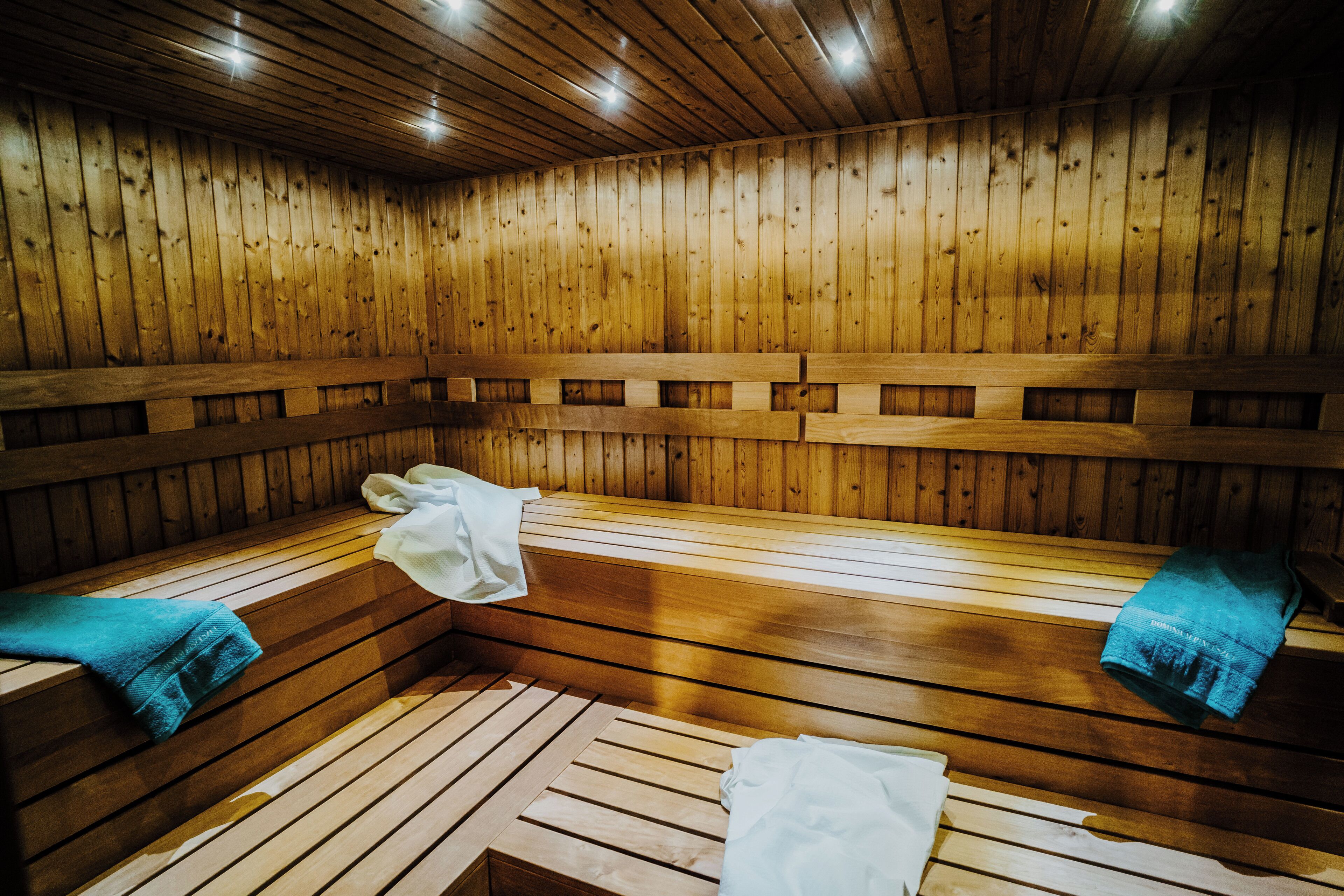 Uma sala de sauna com bancos e toalhas, incluindo um banco com uma toalha.