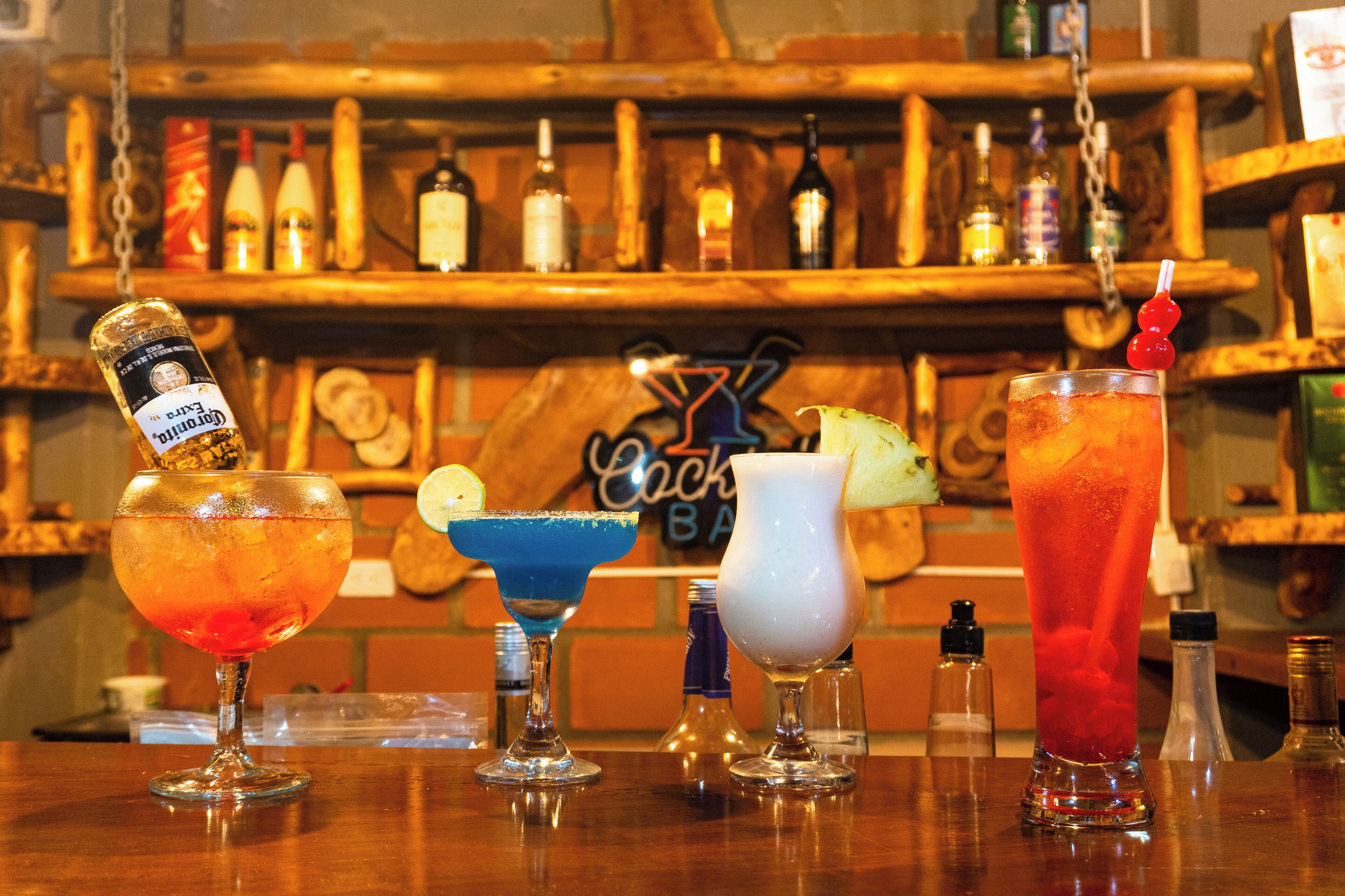 Um bar com diversas bebidas e garrafas ao fundo.