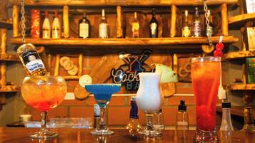 Um bar com diversas bebidas e garrafas ao fundo.