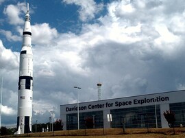 Um centro de exploração espacial com uma estrutura de foguete em destaque e um edifício identificado como 'Davidson Center for Space Exploration'.