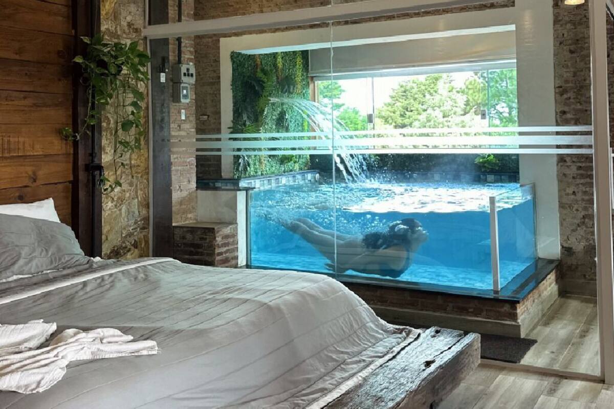Quarto com uma janela grande com vista para uma piscina.