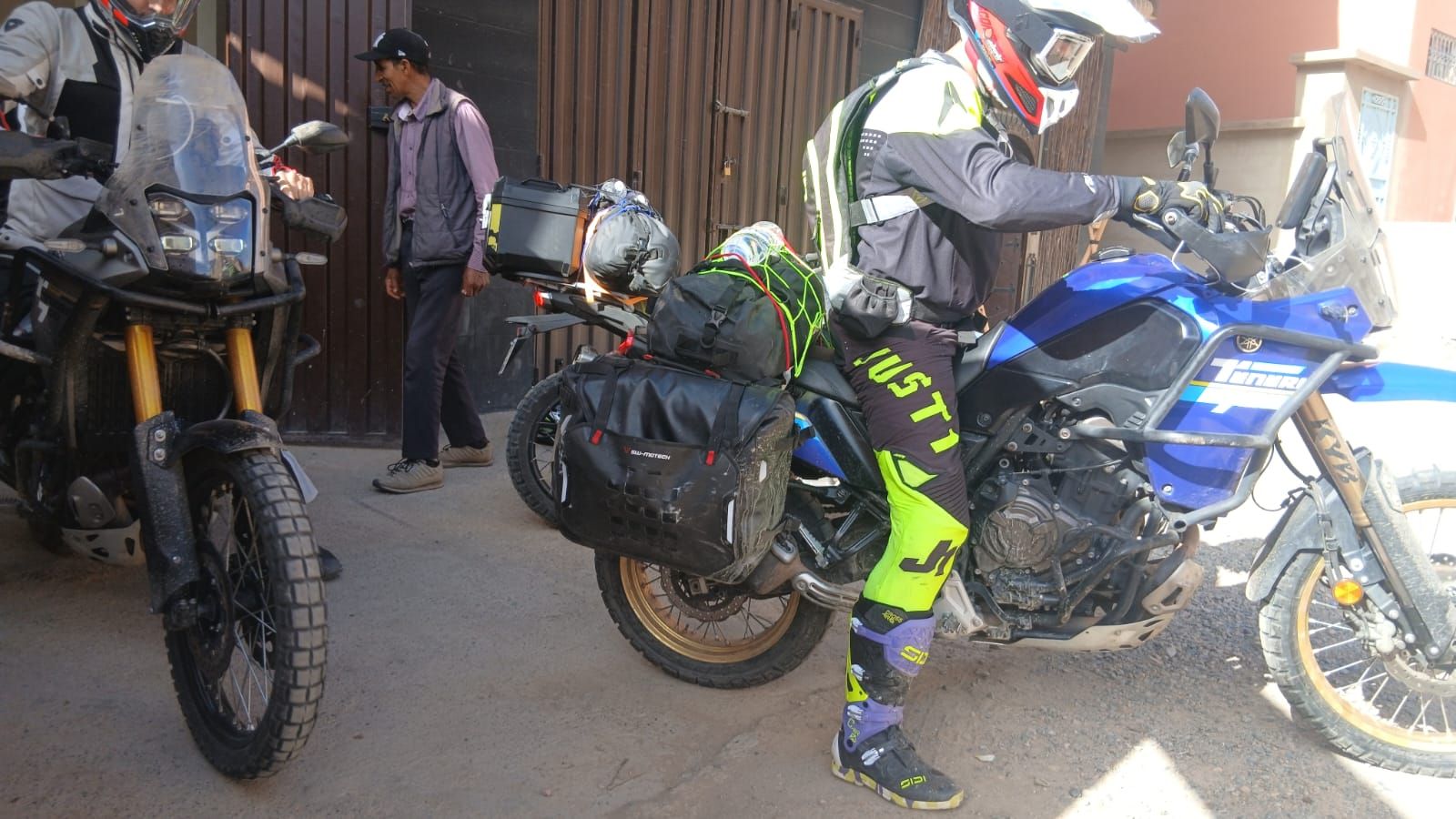 Um grupo de motocicletas estacionadas ao ar livre, com motociclistas usando equipamentos de proteção.