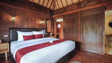 Uma cama grande com roupa de cama branca e vermelha, paredes de madeira e teto de tecido.