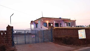 Um edifício com portão e placa indicando quartos disponíveis.