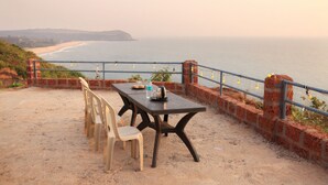 Uma mesa com cadeiras e vista para a praia.