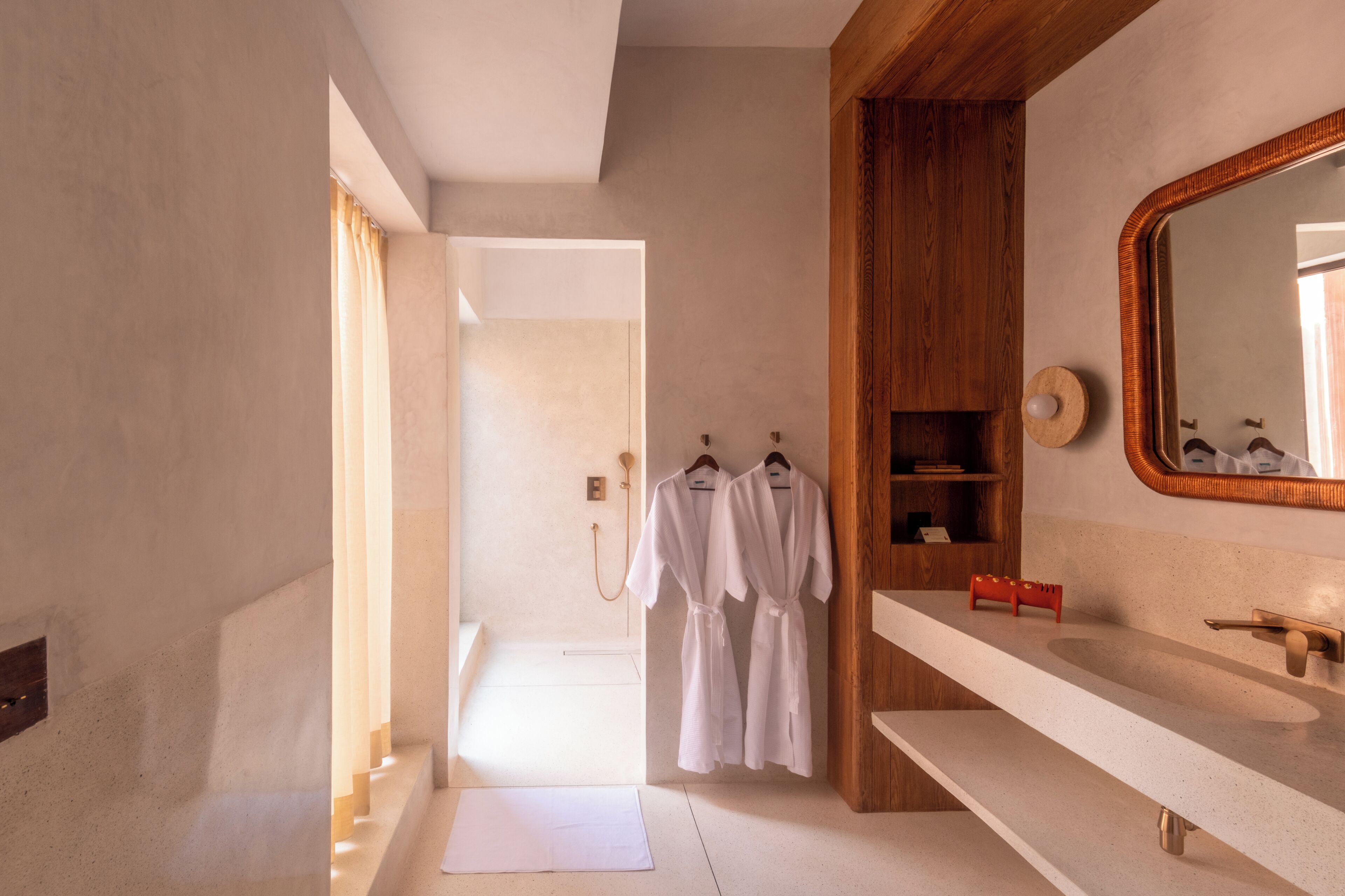 Uma casa de banho moderna com chuveiro, um lavatório com espelho e um porta-toalhas.