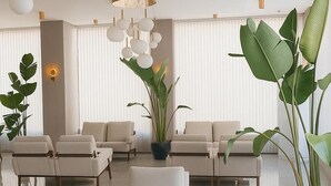 Uma área de estar moderna, com sofás, uma mesa de centro e luminárias esféricas penduradas.