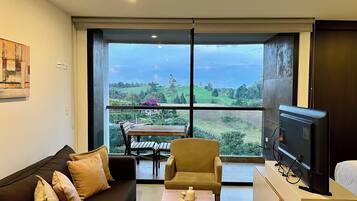 Suite Deluxe, vista para o jardim | Sala de estar | Smart TV