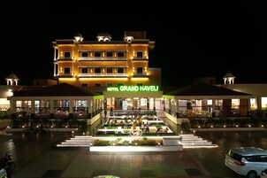 Um hotel com uma placa chamativa, várias varandas e um pátio central com áreas de estar.