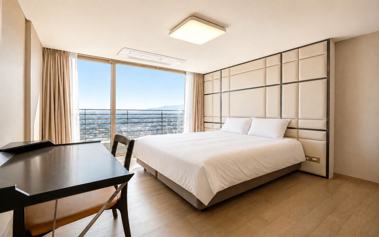 Quarto de hotel com uma cama grande, uma escrivaninha e vista para a cidade.