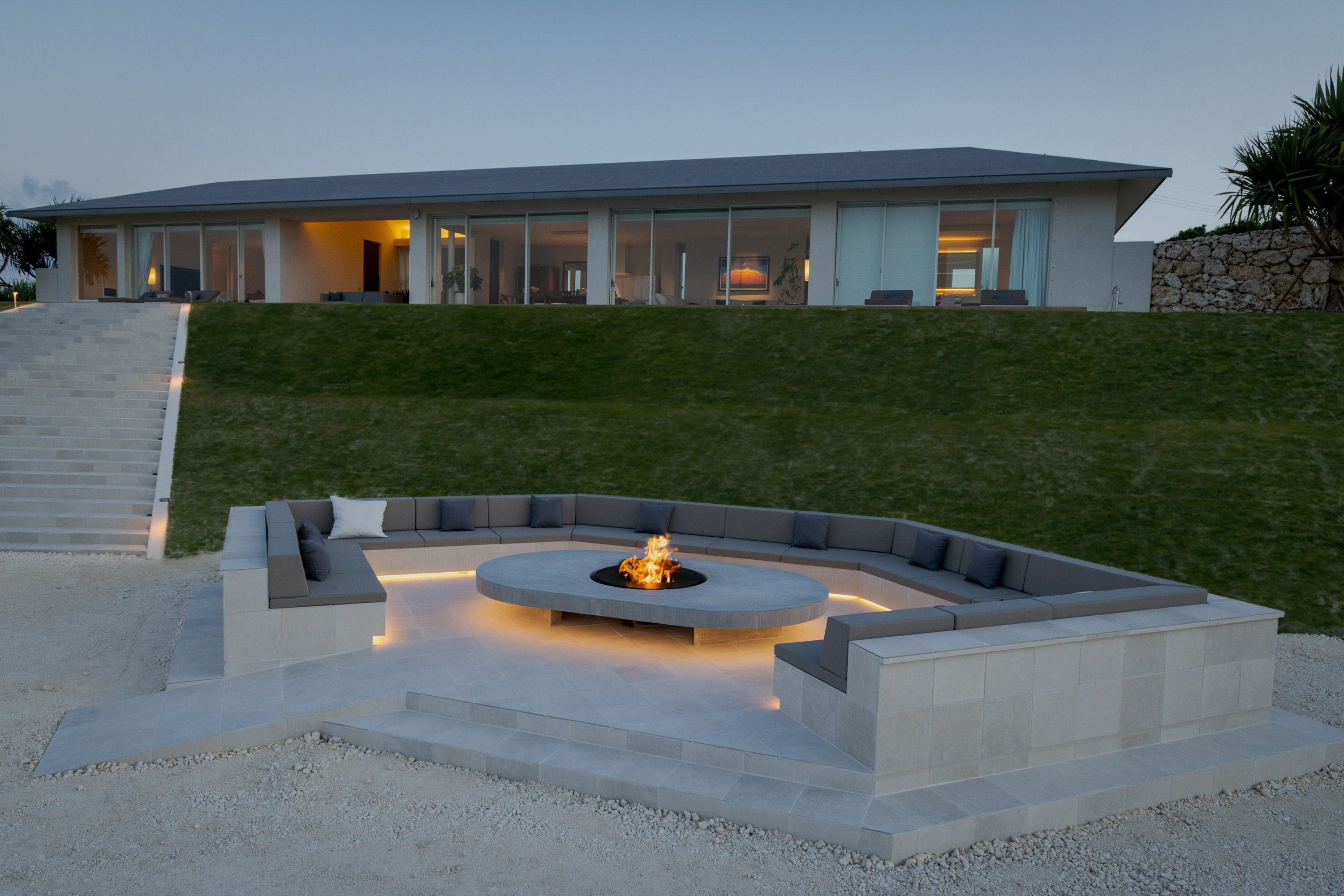 Uma casa moderna com área externa circular de estar e lareira.