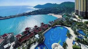 Resort com uma piscina grande, acesso à praia e edifícios altos.