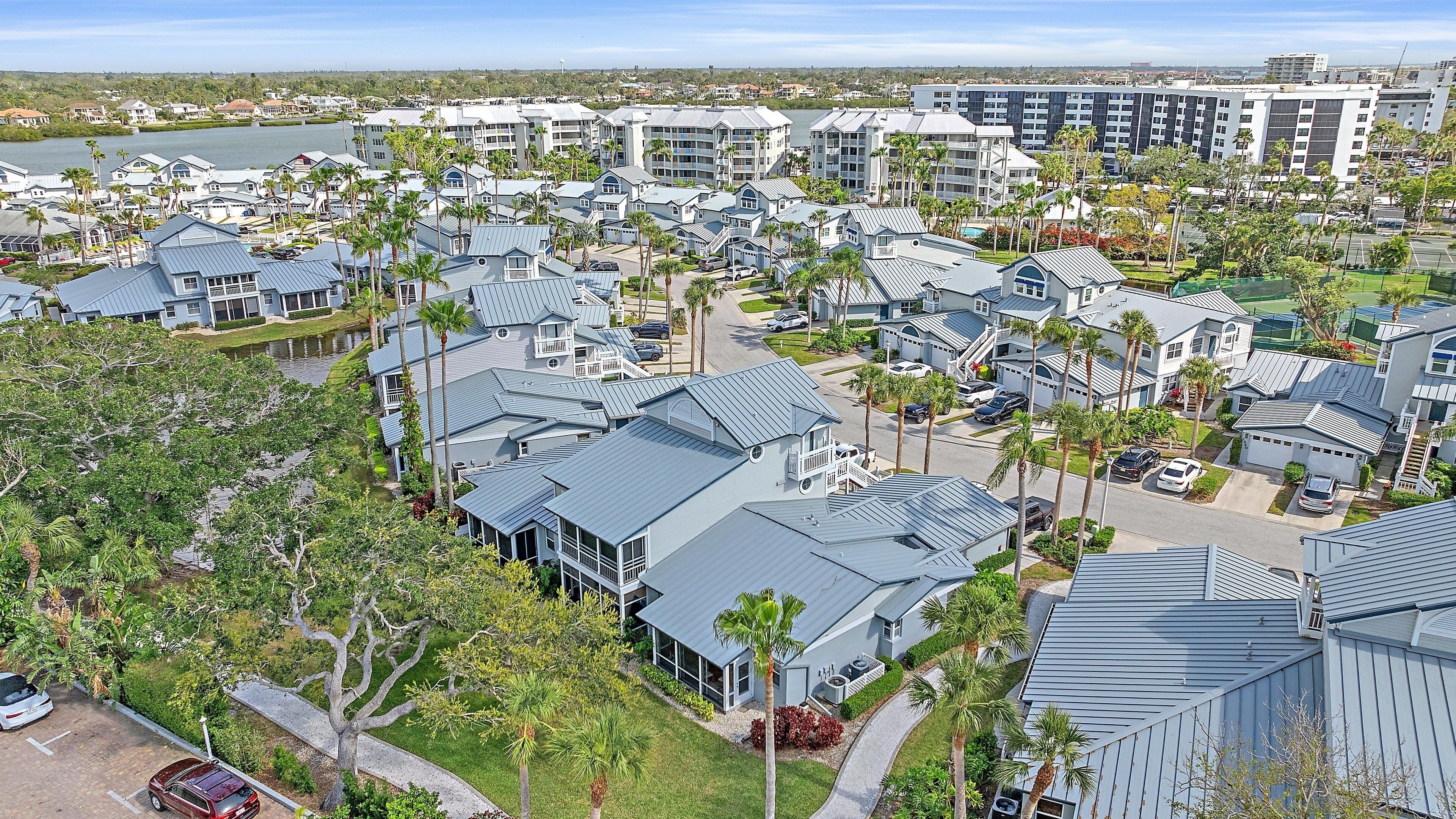 Área residencial com várias casas, um corpo de água e um edifício grande ao fundo.