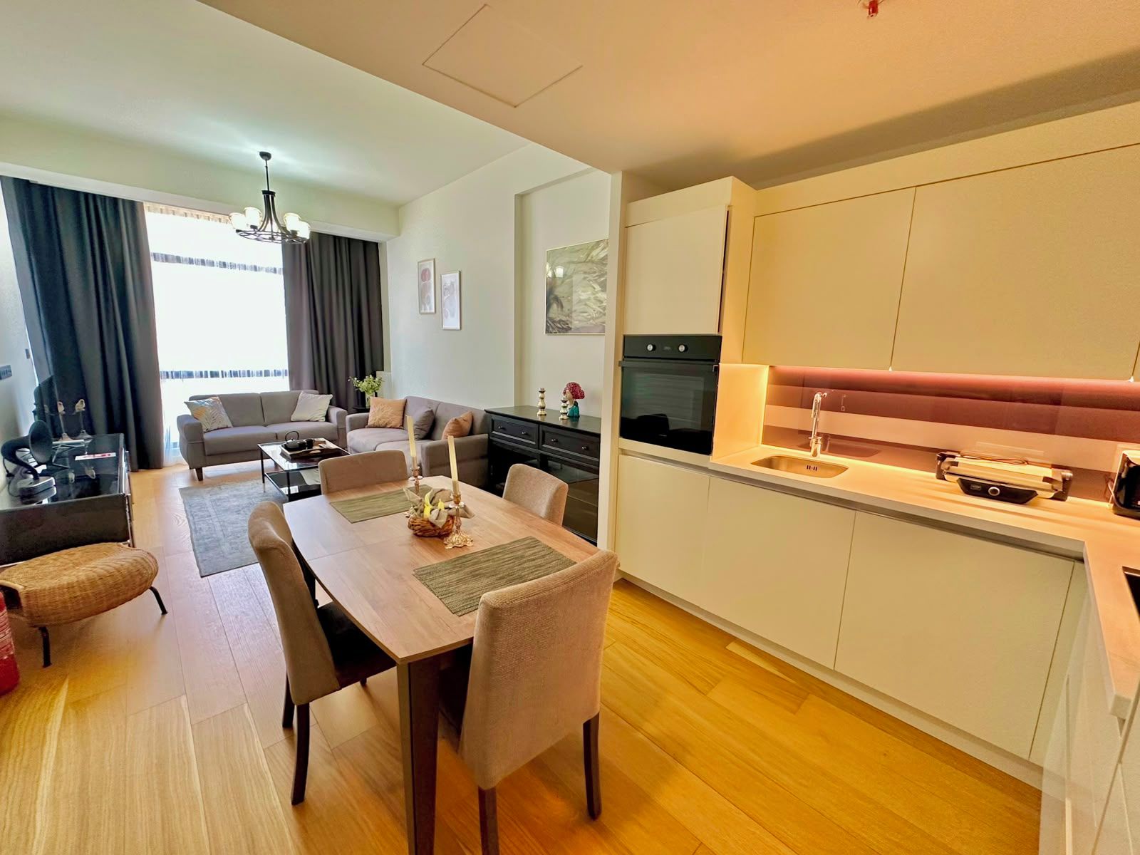 Um apartamento moderno com área de jantar, cozinha e sala de estar.