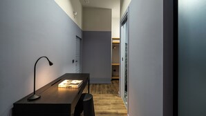 Um corredor estreito com uma mesa, uma cadeira e um livro sobre a mesa.