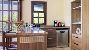 Cozinha com armários de madeira, máquina de lavar louça e cafeteira.