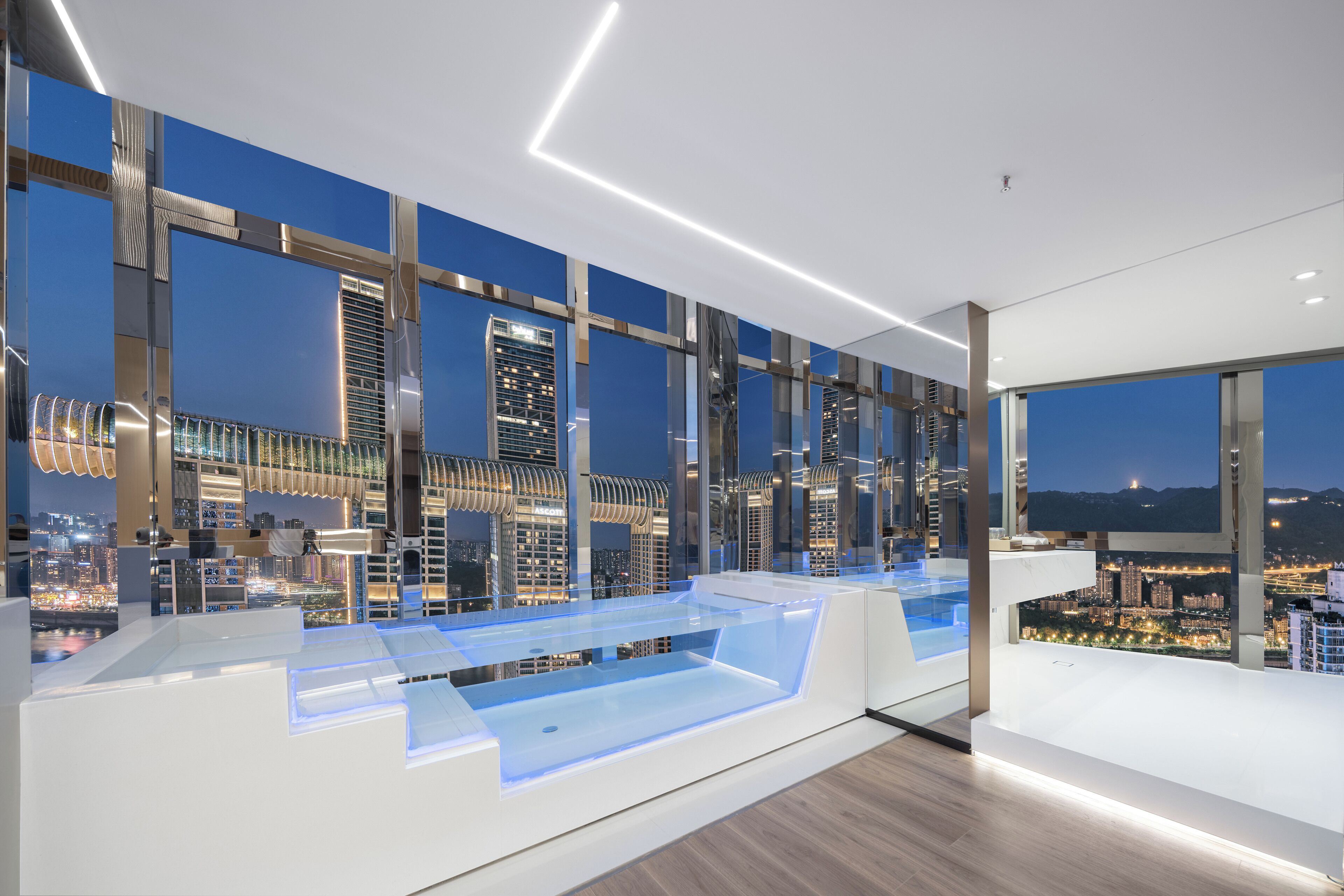 Quarto de hotel moderno com vista para a cidade, janelas amplas e design minimalista.