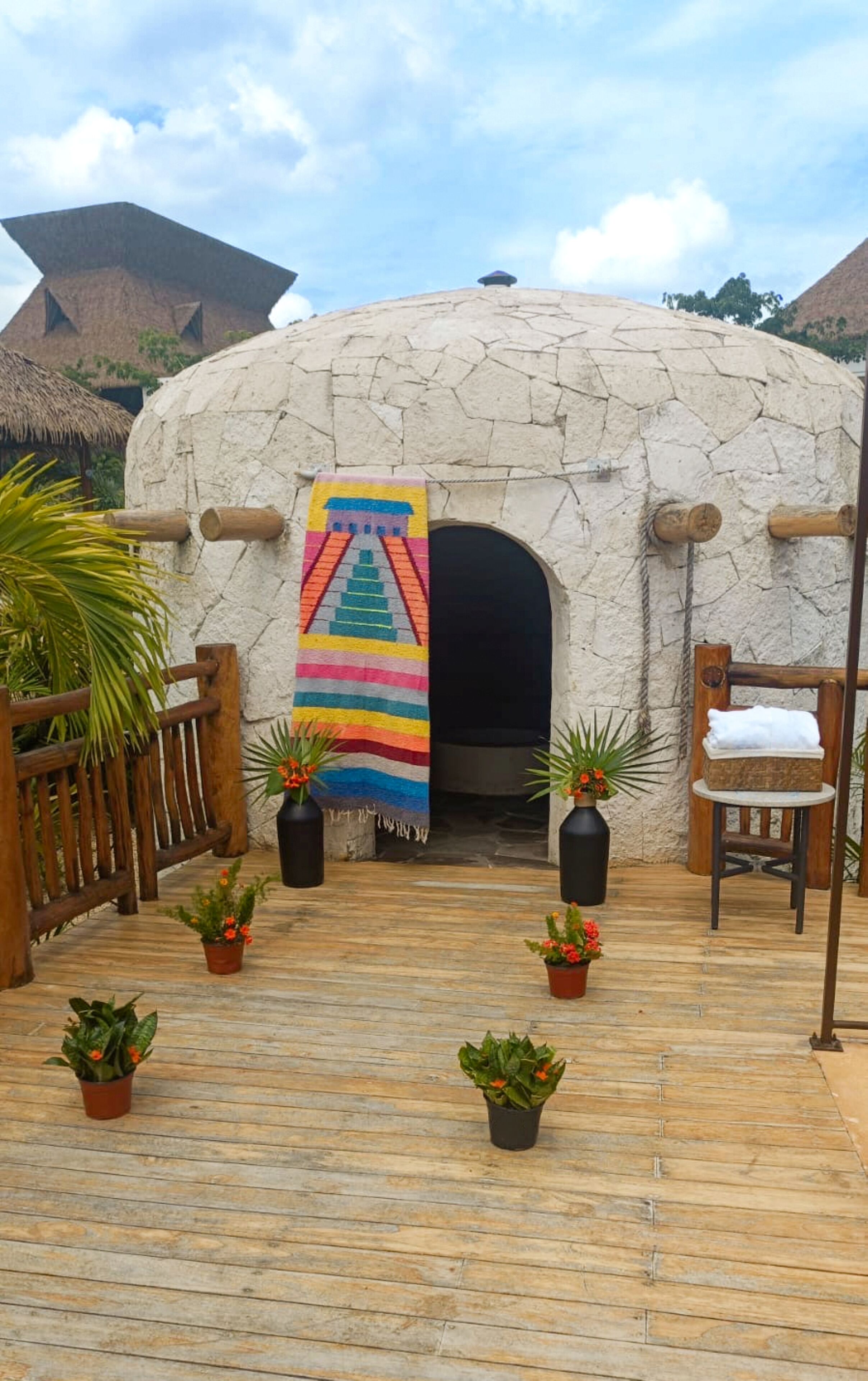 Um edifício rústico de pedra com um tecido colorido listrado pendurado sobre a entrada.
