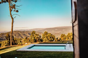 Piscina com vista para montanhas e árvores.