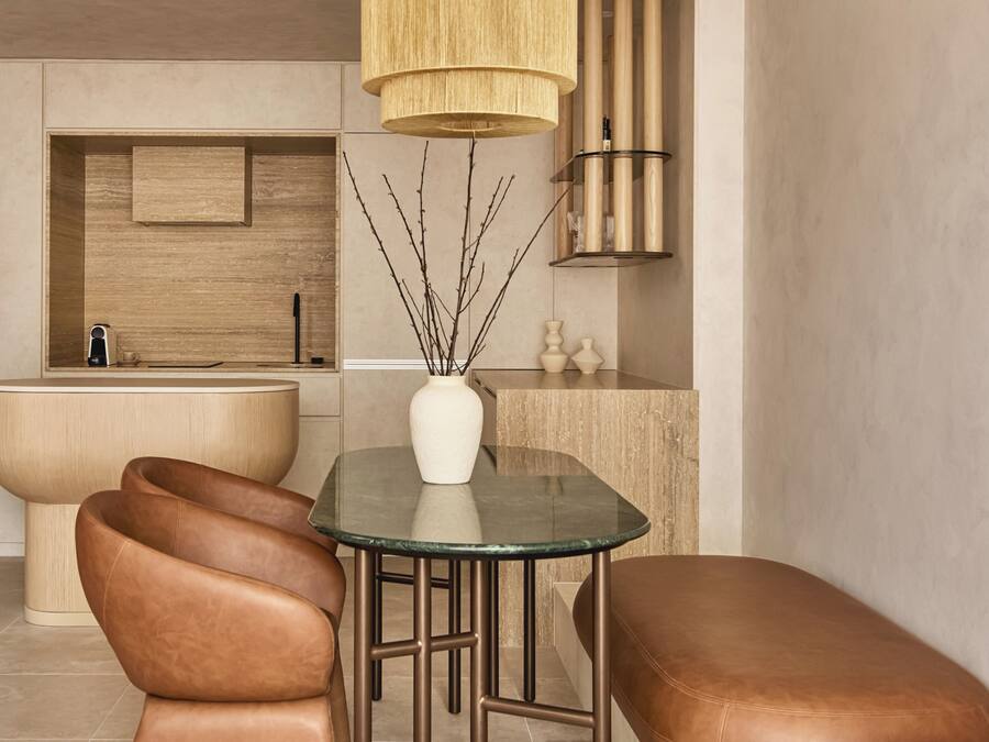 Cozinha moderna com ilha central, área de jantar com mesa de vidro e um espaço de estar.