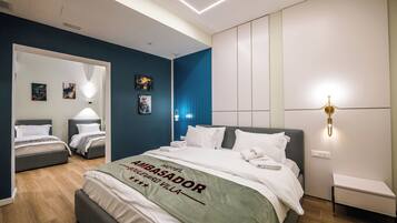 Quarto de hotel com uma cama grande, mesas de cabeceira, um espelho e obras de arte nas paredes.