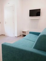 Apartamento Deluxe, 1 cama queen-size e sofá-cama | Sala de estar | Televisor