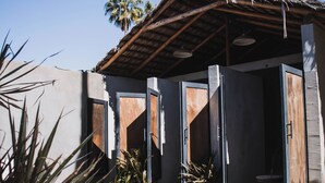 Um edifício com telhado rústico, portas de madeira e fachada de concreto.