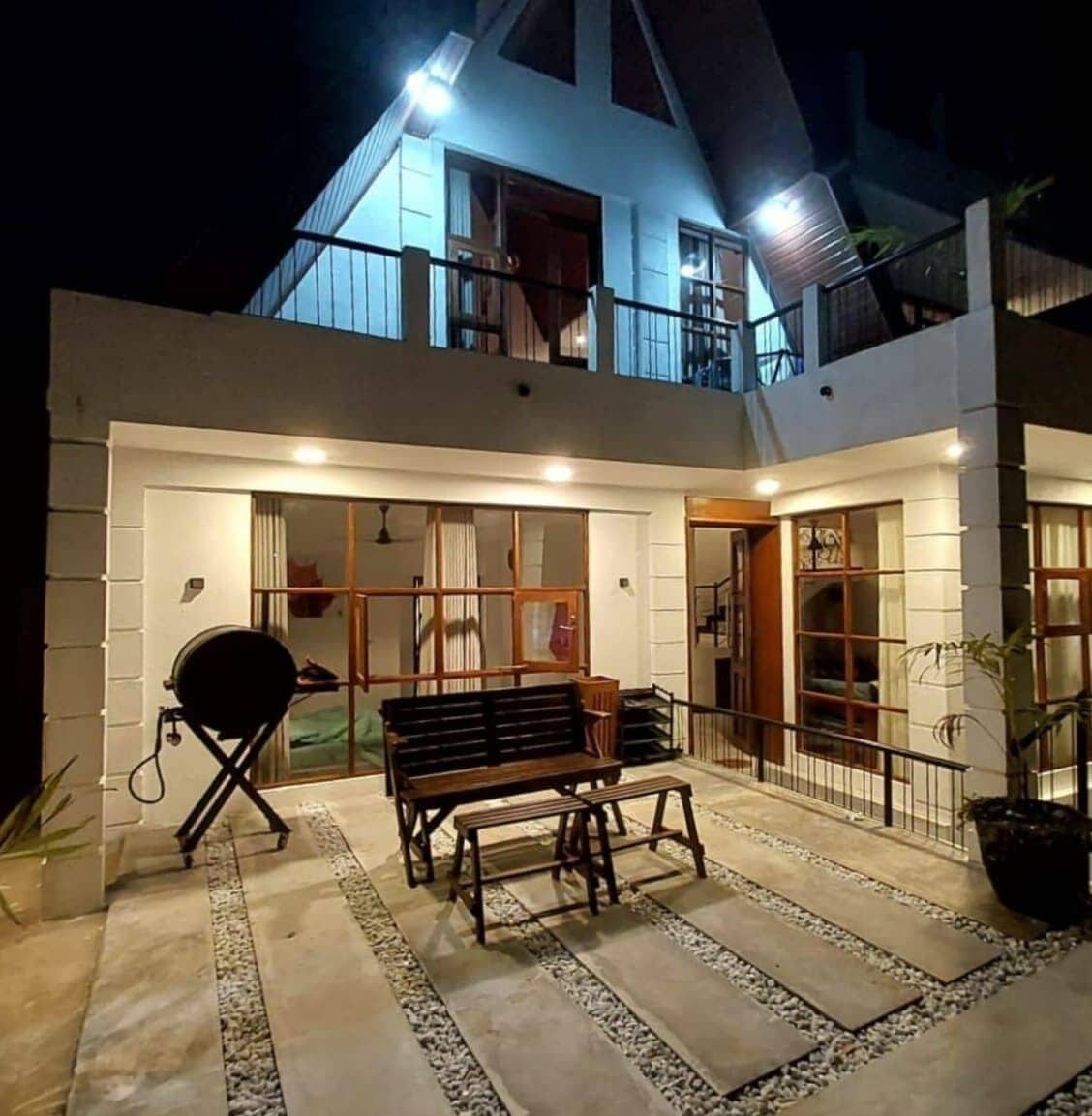 Um edifício de dois andares com varanda e um espaço de pátio.