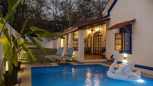 Uma piscina com espreguiçadeiras e um flutuador de cisne.