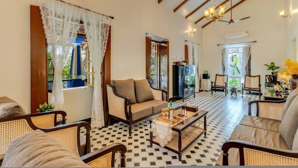Uma sala de estar ampla com piso xadrez, um sofá e uma mesa de centro.
