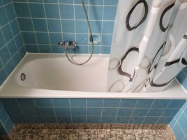 Banheira e chuveiro separados, toalhas de banho, sabonete 