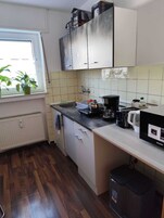 Refrigerador em uma área comum, micro-ondas, fogão, cooktop