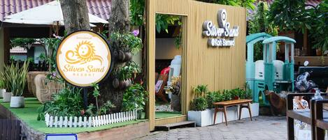 Entrada de resort com placa, estrutura de madeira e uma scooter.
