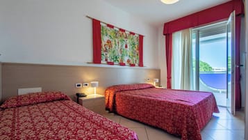 Quarto de hotel com duas camas, uma janela grande e uma vista, e uma obra de arte na parede.