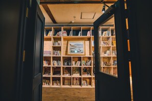Uma biblioteca com estantes de madeira e uma moldura na parede.