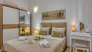 Quarto bem organizado com cama, abajures, espelho, cômoda e uma obra de arte pendurada na parede.