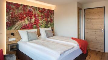 Quarto moderno com cama grande, cabeceira de madeira e vibrante arte de parede floral.