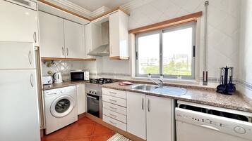 Um micro-ondas, uma máquina de lavar louça, uma cafeteira/bule