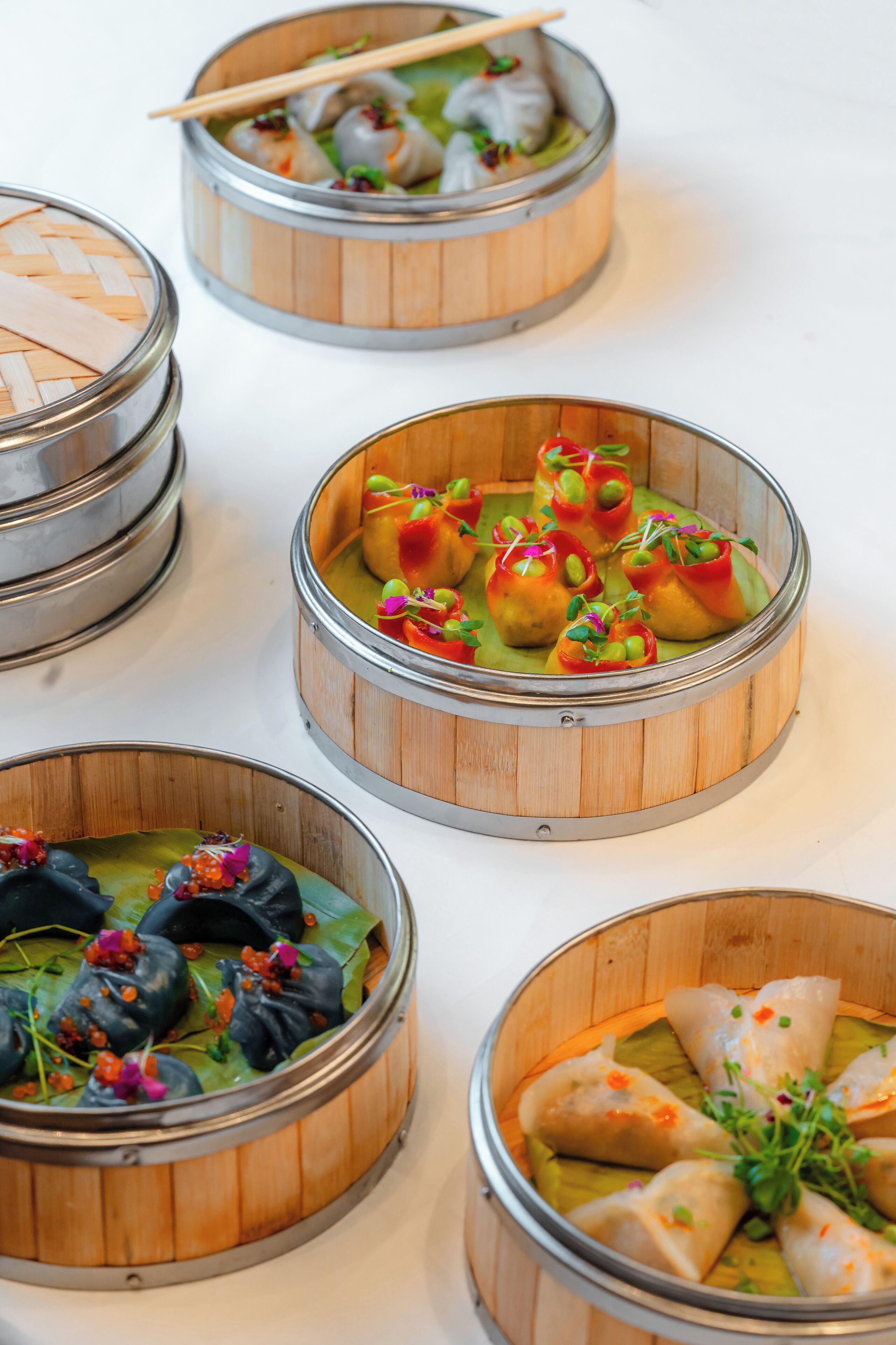 Diversos pratos de dim sum em cestos de bambu.