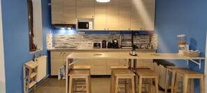 Uma cozinha com armários de madeira, micro-ondas e banquetas de bar.
