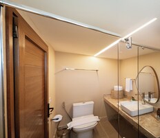 Suíte luxo, 1 cama Queen, sacada, vista parcial para o mar | Banheiro | Chuveiro, secador de cabelo, roupões de banho, toalhas de banho