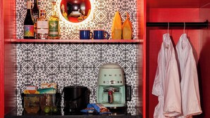 Quarto de hotel compacto com minibar, máquina de café e frigorífico.