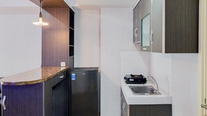 Cozinha compacta com geladeira embutida, pia e bancada.